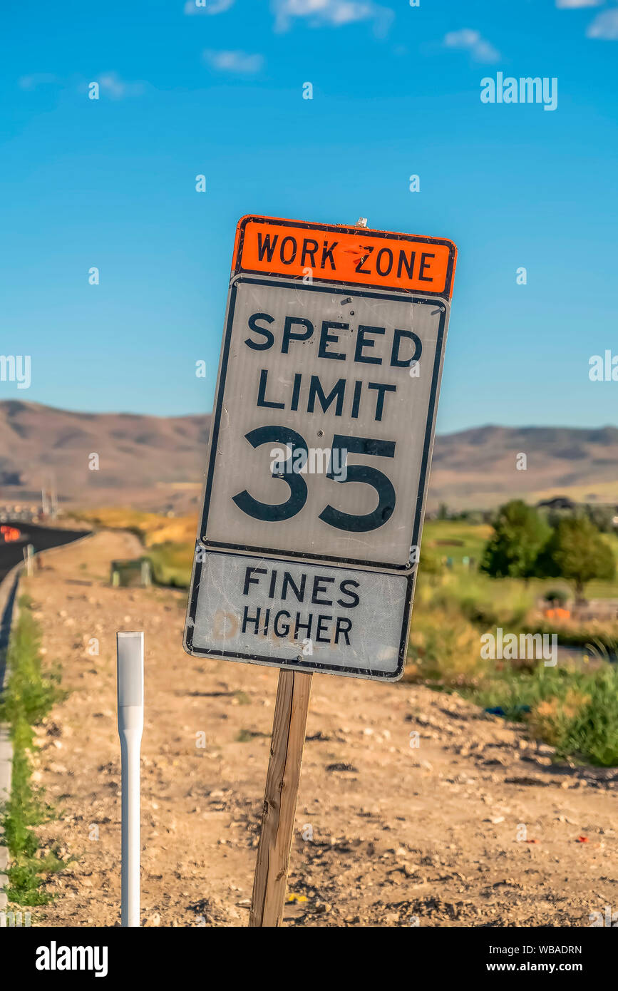 Close up of speed limit sign against dry ground mountain and sky on a ...
