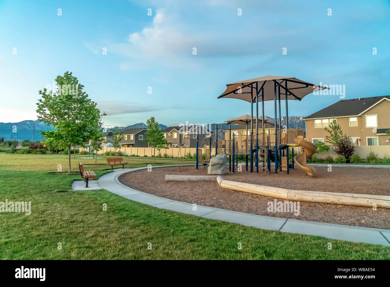 Neighborhood park with benches and pathway around a childrens ...