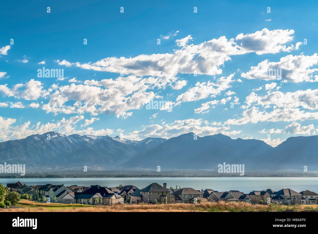 Picturesque landscape with homes overlooking a blue lake and towering ...