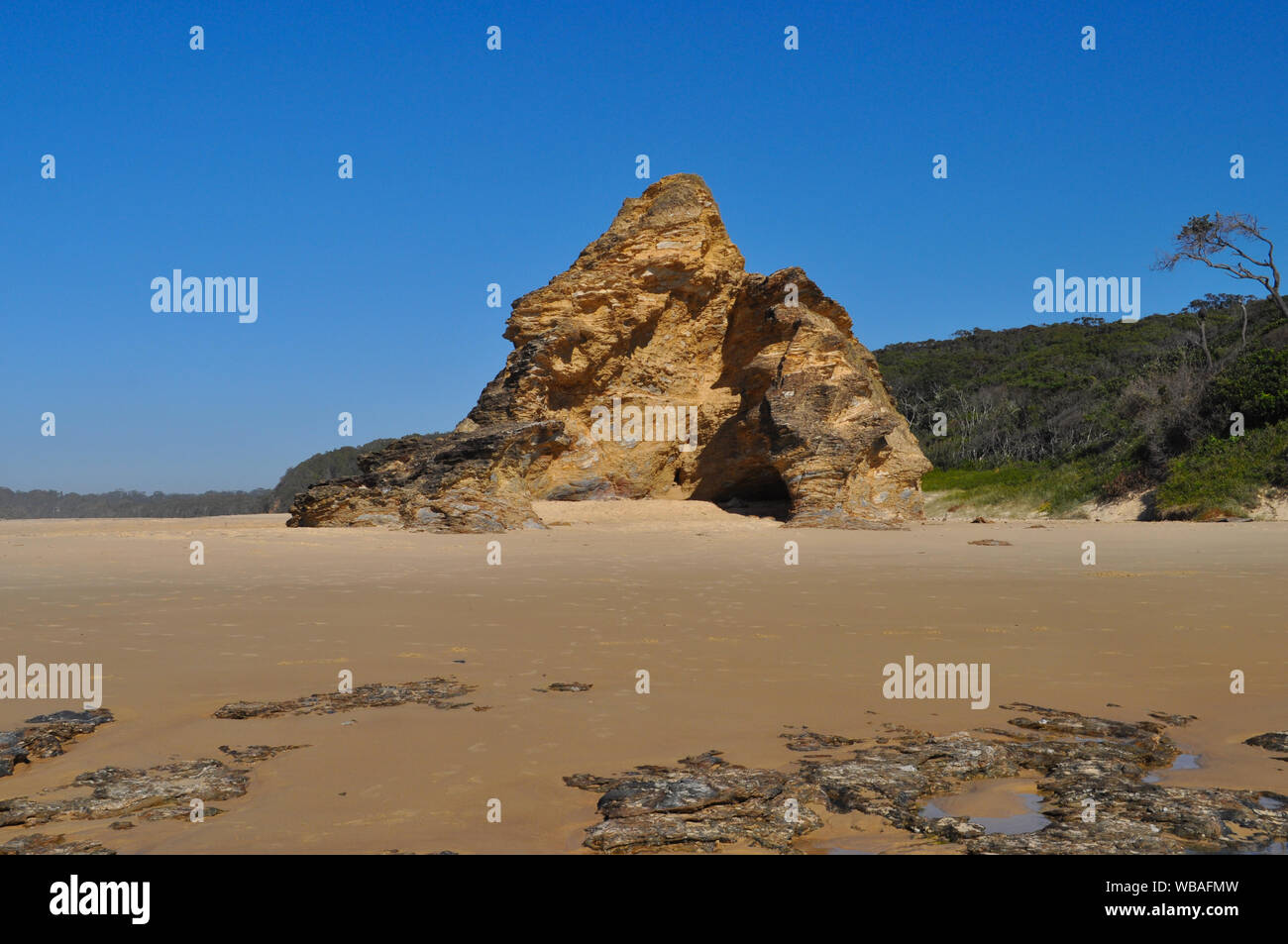 Iconic rock feature, a rock cave on South Valla Beach with clear blue ...