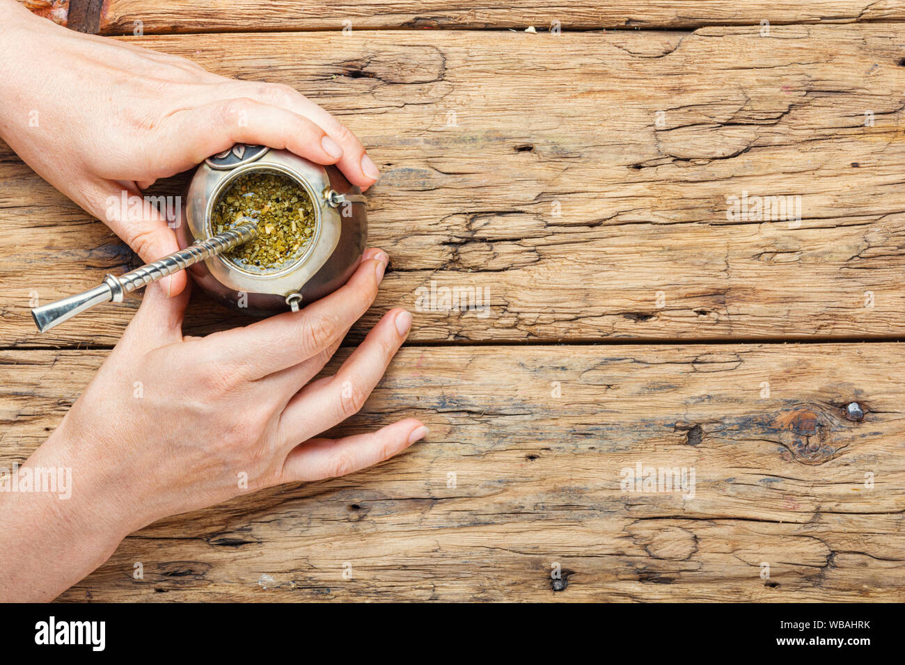 Cup with mate tea in the hands of a man.Yerba mate in calabash and dry ...