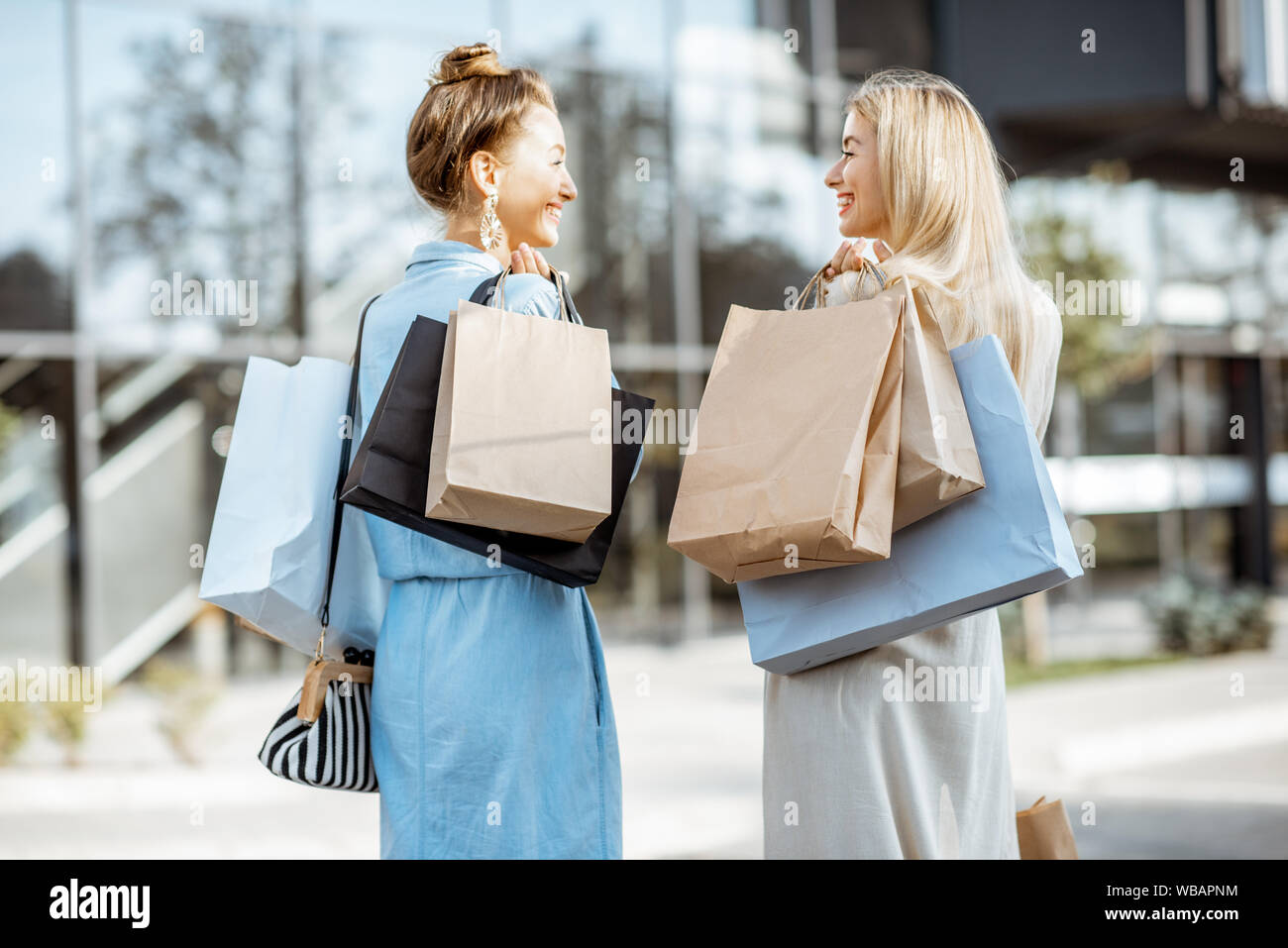 Two women holding empty shopping bags with copy space, while standing ...
