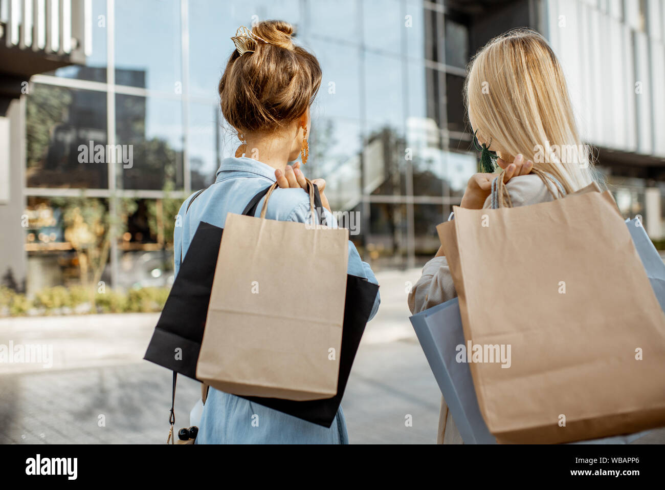 Two women holding empty shopping bags with copy space, while standing ...