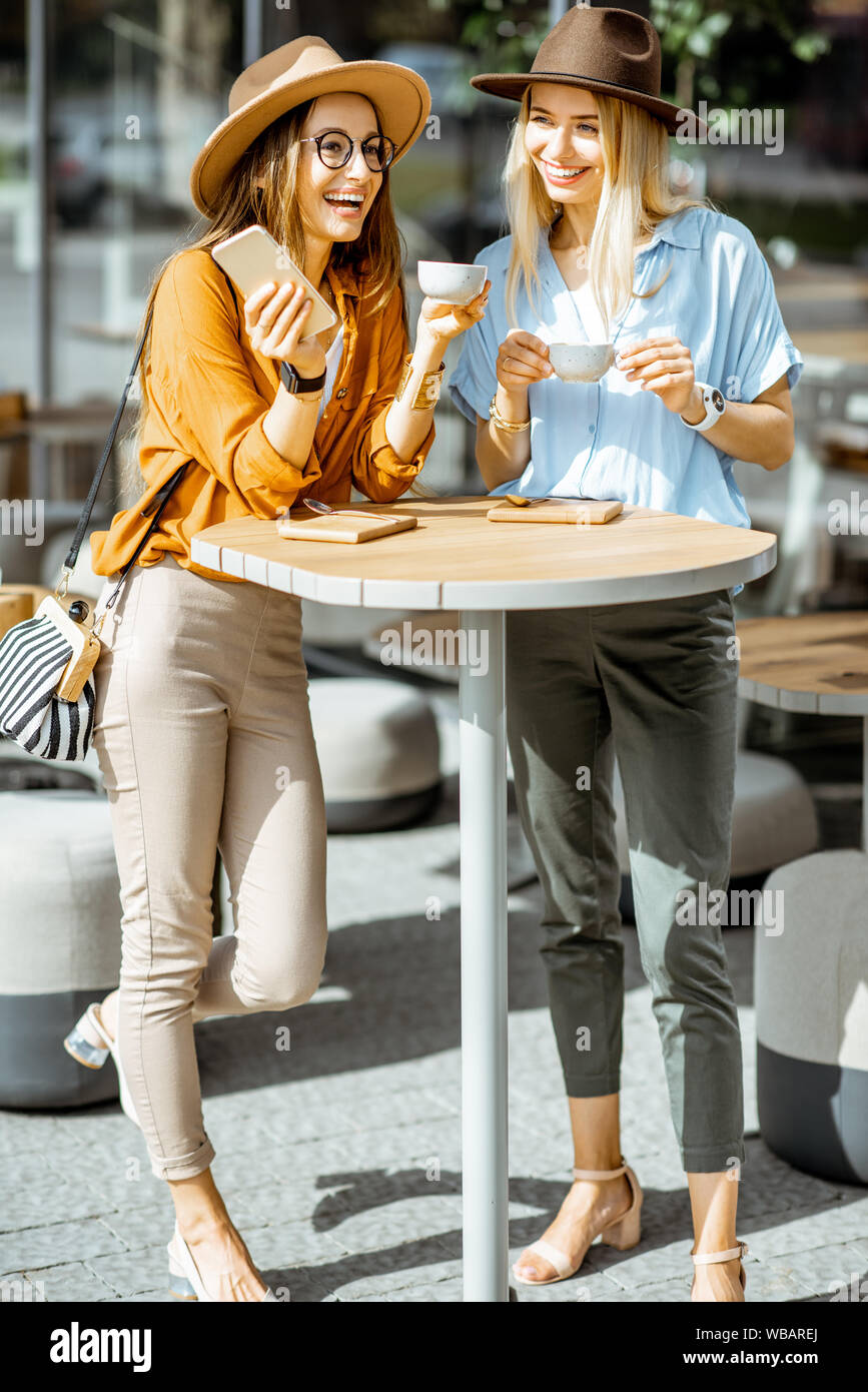 Two female best friends spending time together on the cafe terrace ...