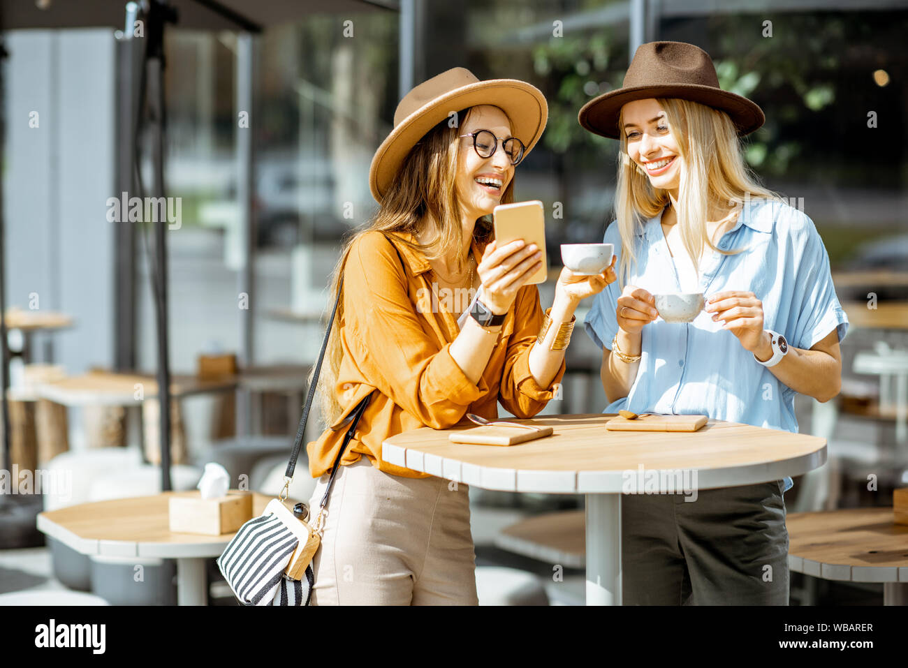 Two female best friends spending time together on the cafe terrace ...