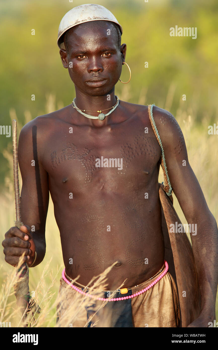Young Suri man digging gold in South Omo, Ethiopia Stock Photo - Alamy