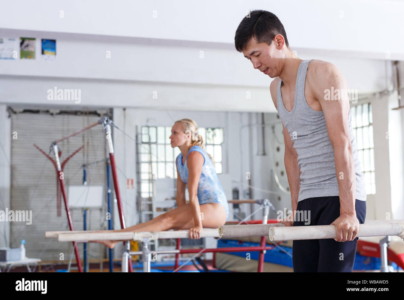 Fit couple man and woman doing acrobatic exercises on gymnastic ...