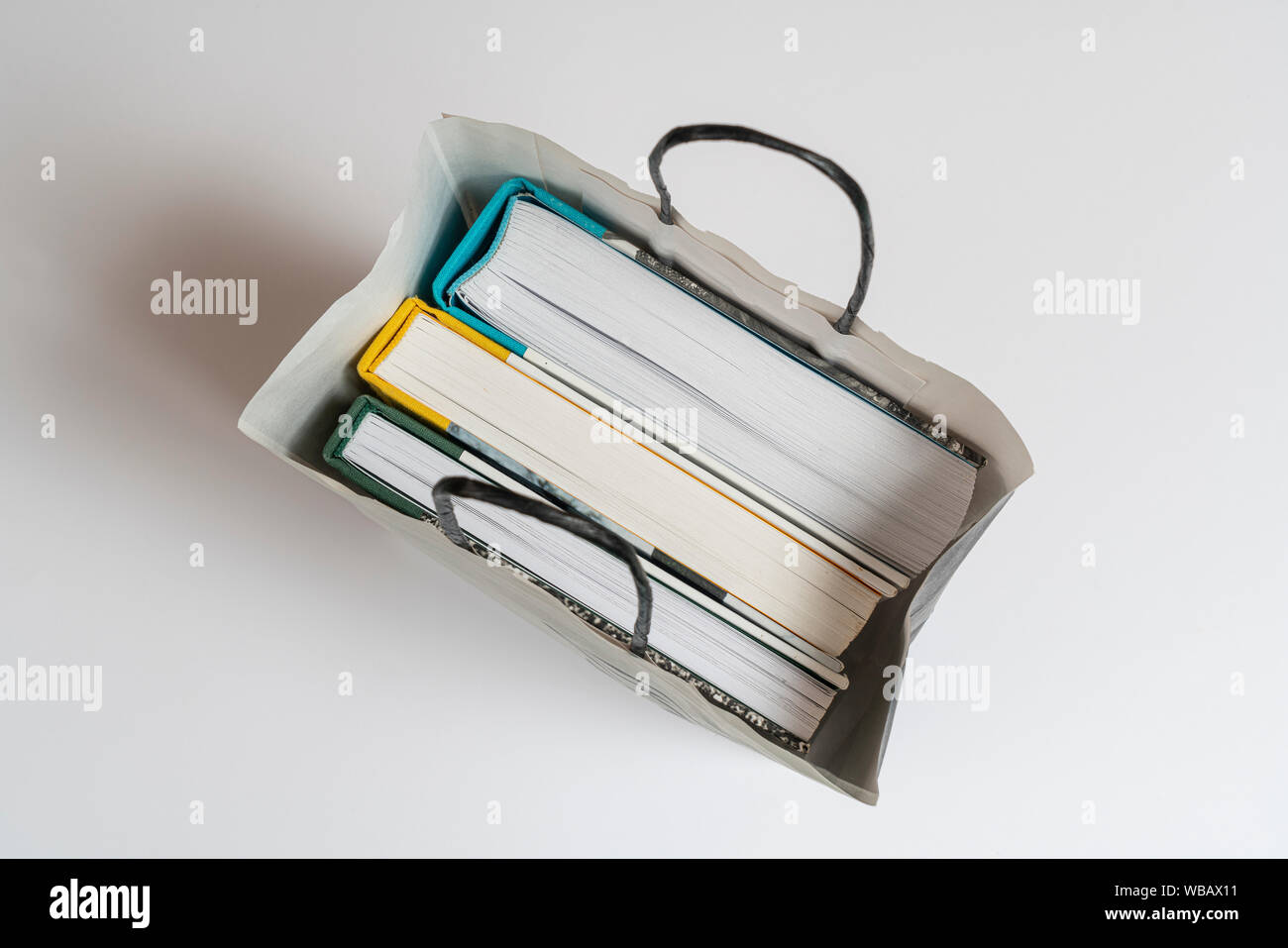 some books inside a white paper bag on the table Stock Photo - Alamy