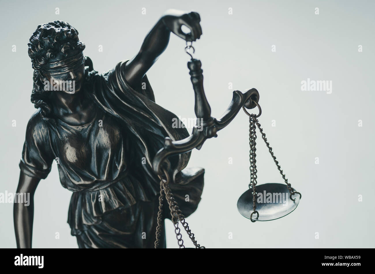 Statue of Justice holding aloft scales in her hand symbolic of law ...