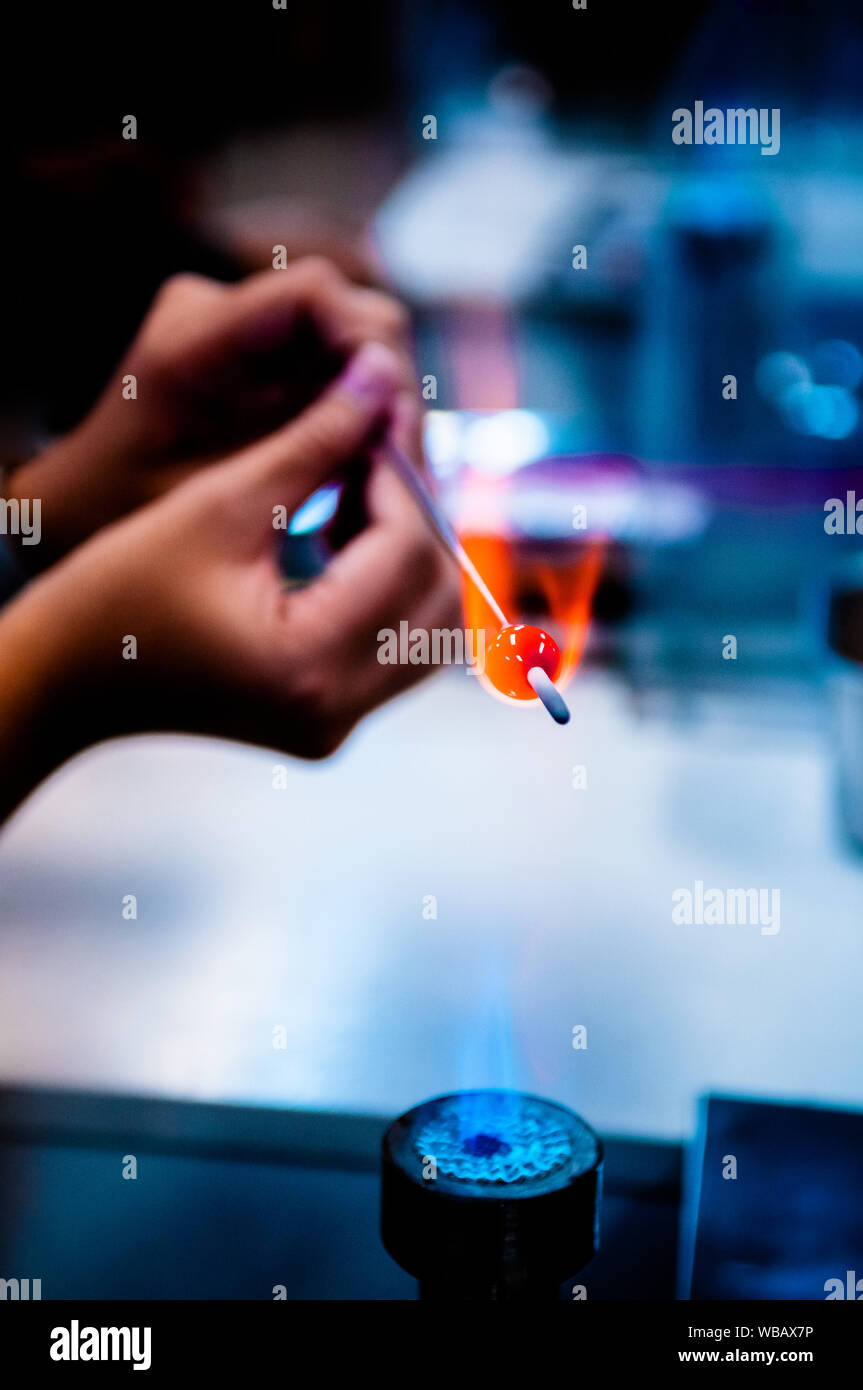 Glass blower carefully heat up a glass ball Stock Photo - Alamy