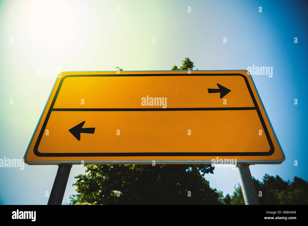 Yellow traffic board with left and right directions Stock Photo - Alamy