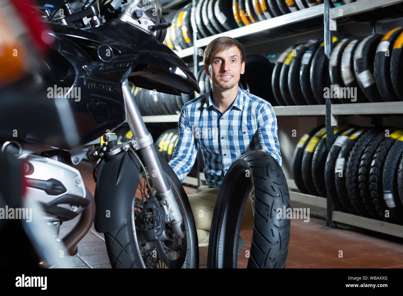 Glad man customer holding his motorcycle at maintenance point Stock ...