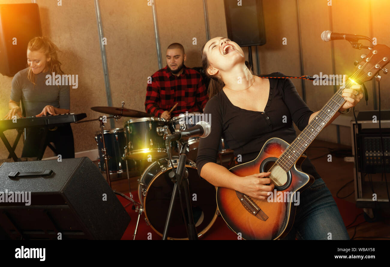 Rehearsal of music band. Ordinary female guitar player and singer ...