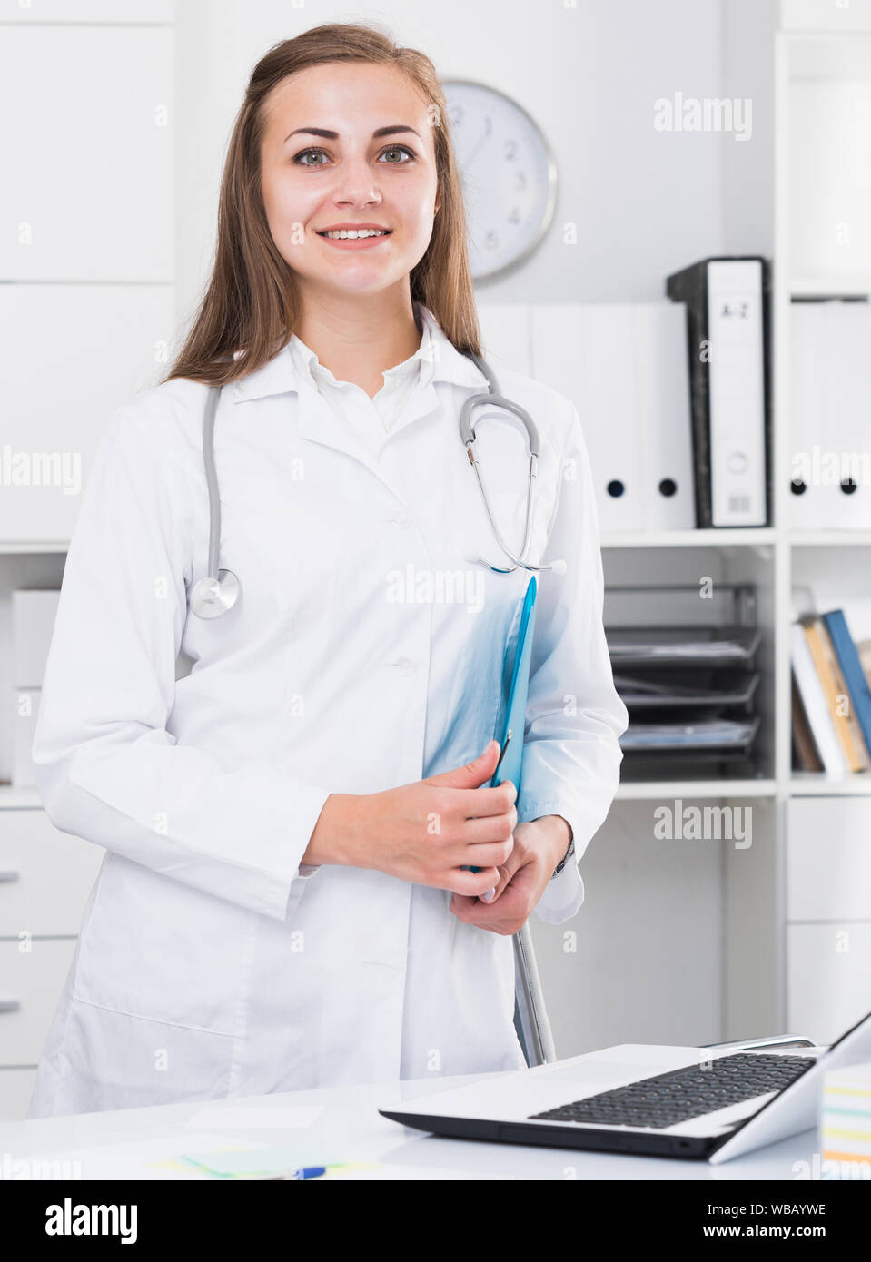 Doctor girl is standing with documents in clinic Stock Photo - Alamy
