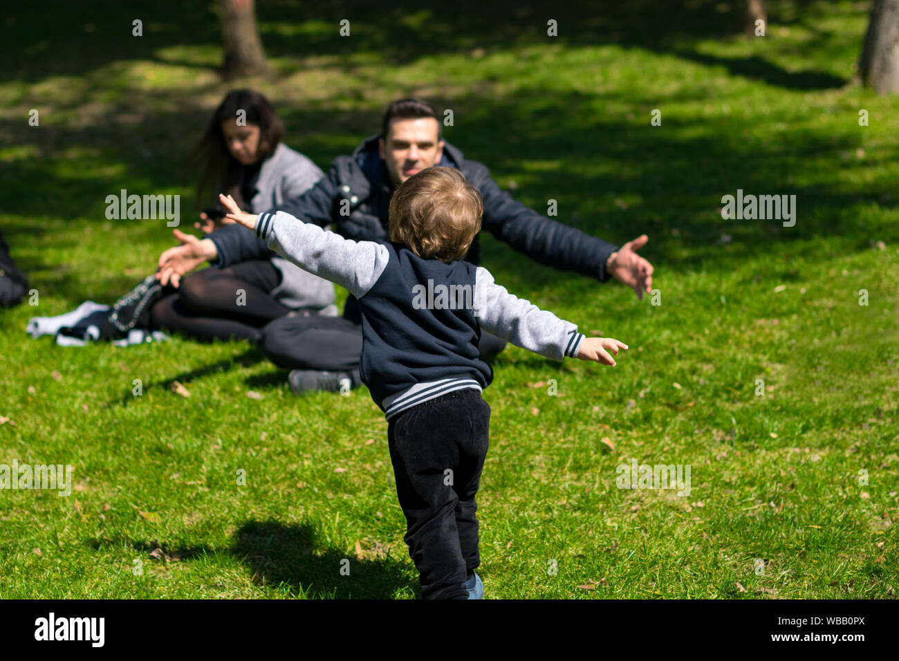 Baby running to his father in spring Stock Photo - Alamy