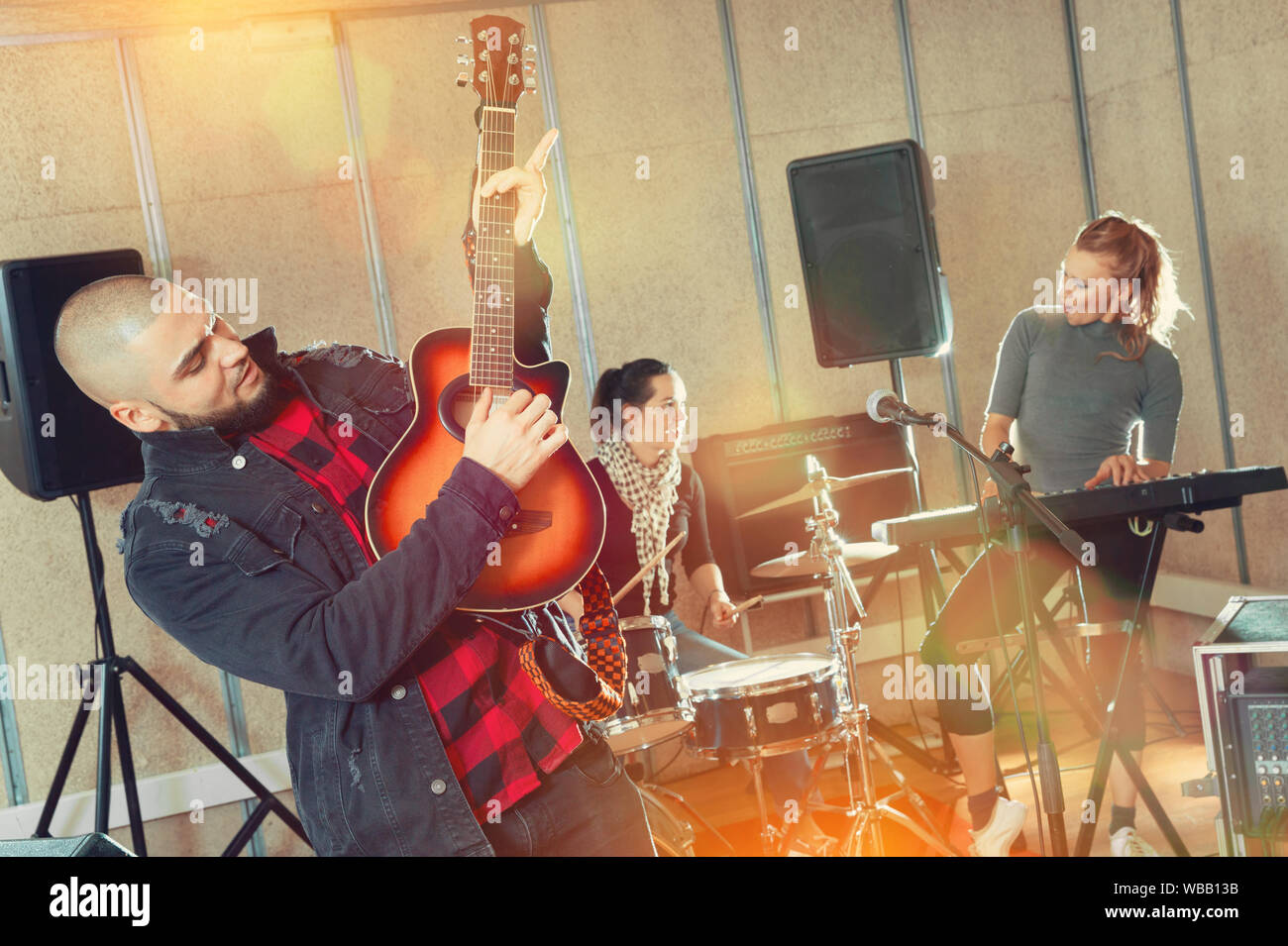 Bearded guy soloist playing the guitar and singing with two girls of ...