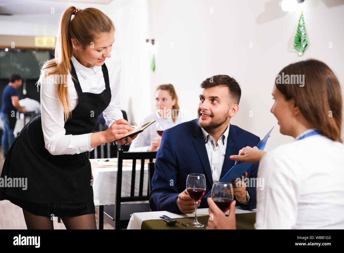 Couple giving order to waiter hi-res stock photography and images - Alamy