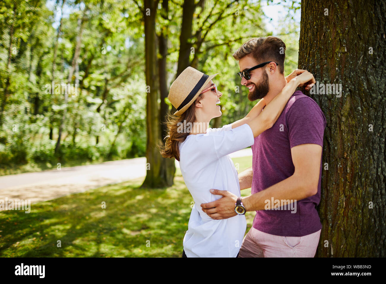 Couple leaning against a tree hi-res stock photography and images - Alamy