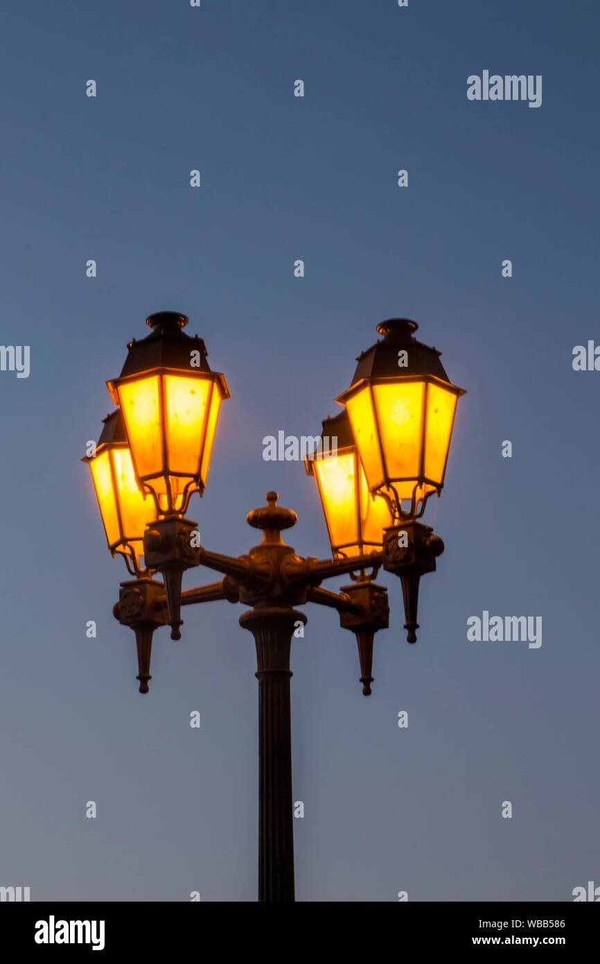 View of typical european streetlight lit at twilight Stock Photo - Alamy