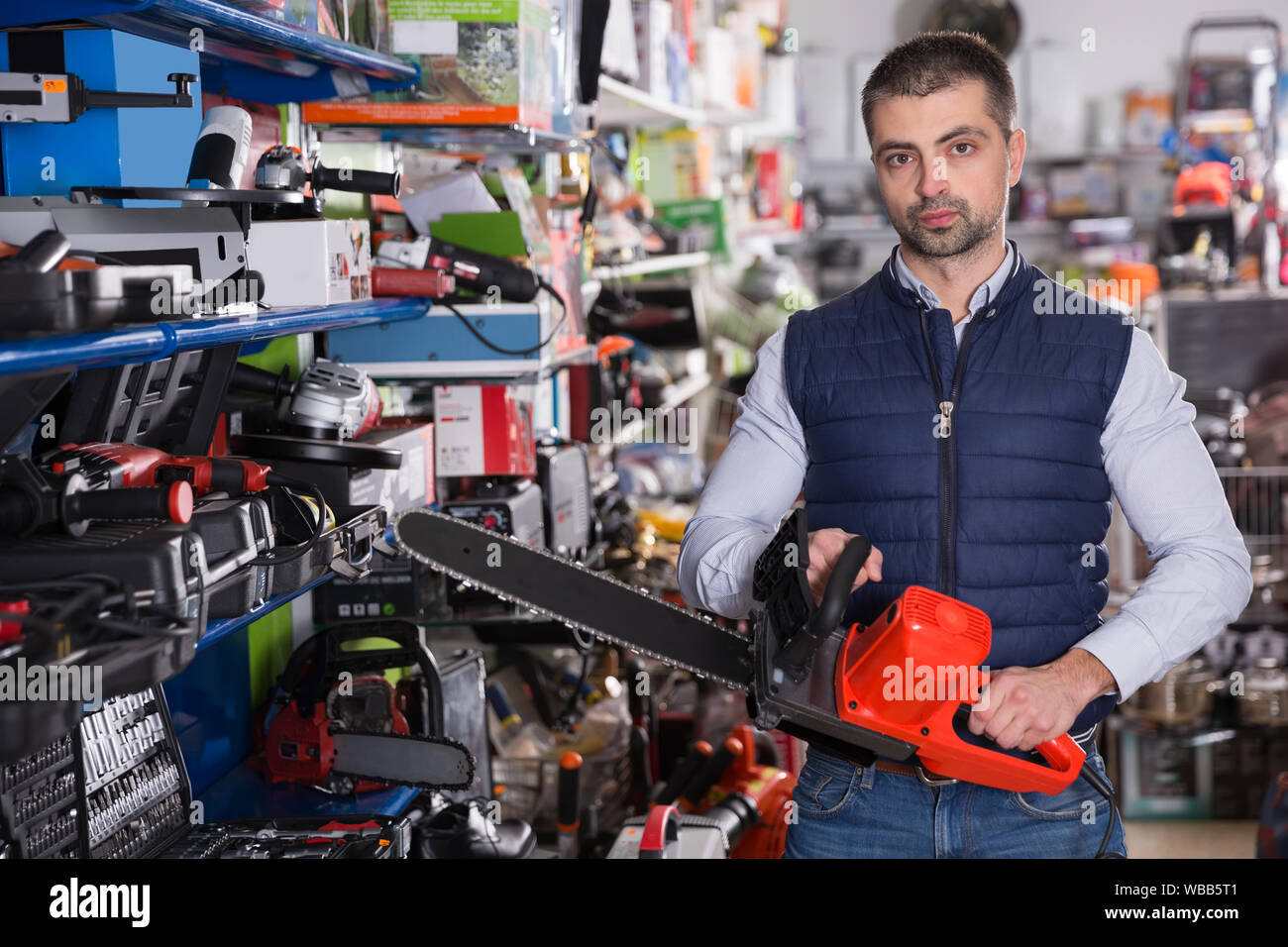 Man is choosing electric saw in tools store Stock Photo - Alamy