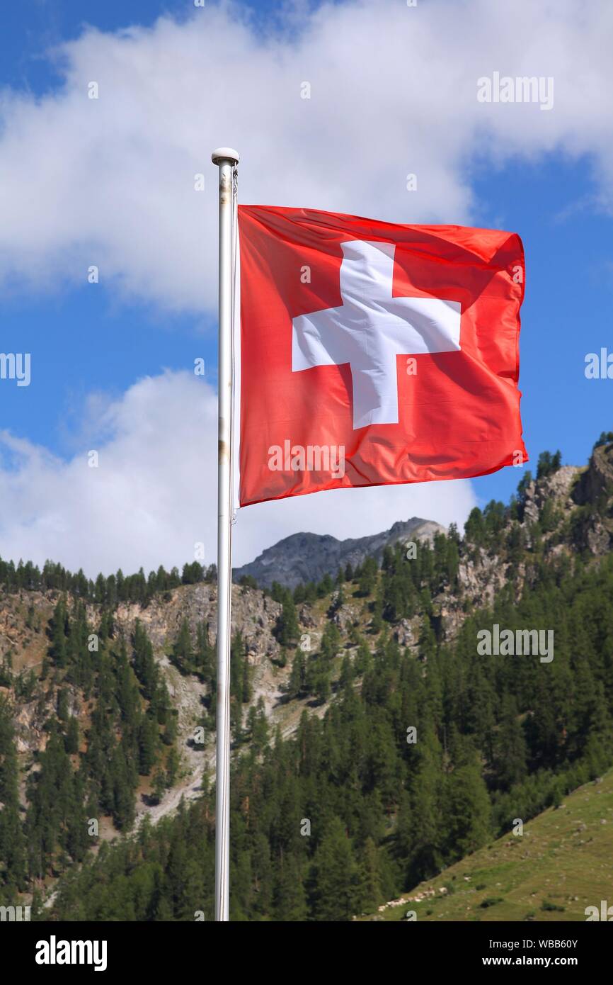 Swiss flag - national symbol of Switzerland with Alps in background ...