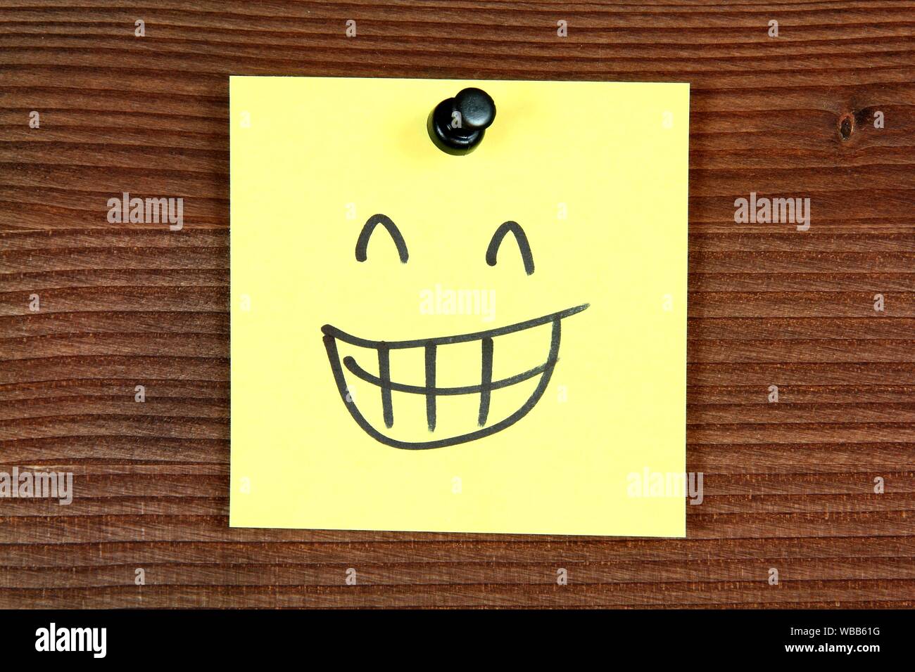 Sticky note with smiley happy face. Bulletin board Stock Photo - Alamy