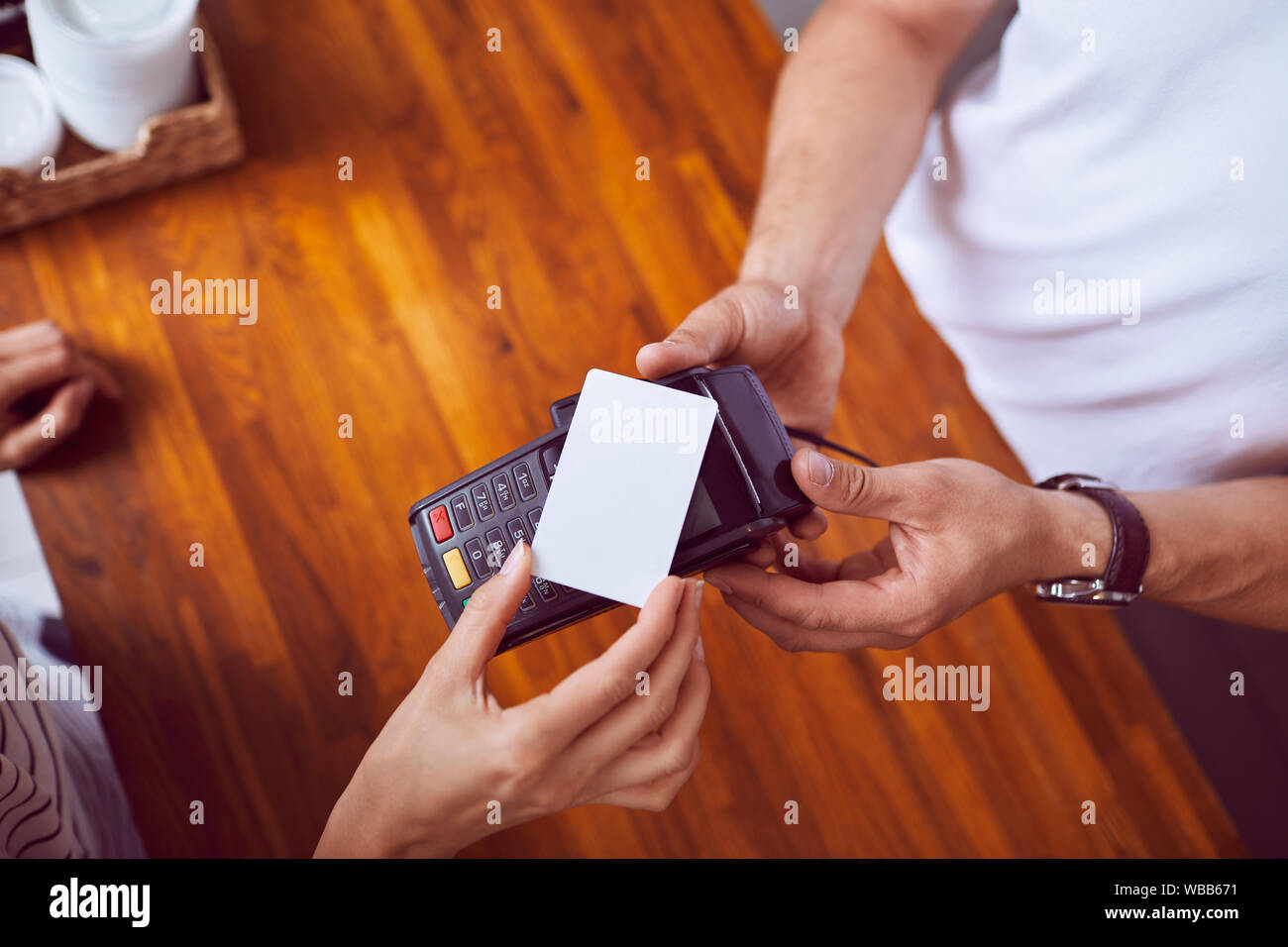 Top view of female hand holding credit card paying with wooden counter ...