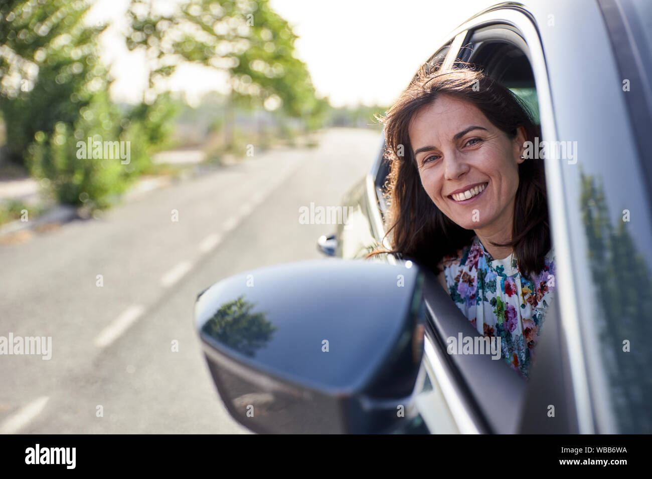 woman sitting in the passenger seat of a car while looking through the ...