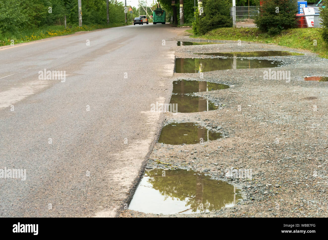 road after rain, puddles on the edges of the asphalt road Stock Photo ...