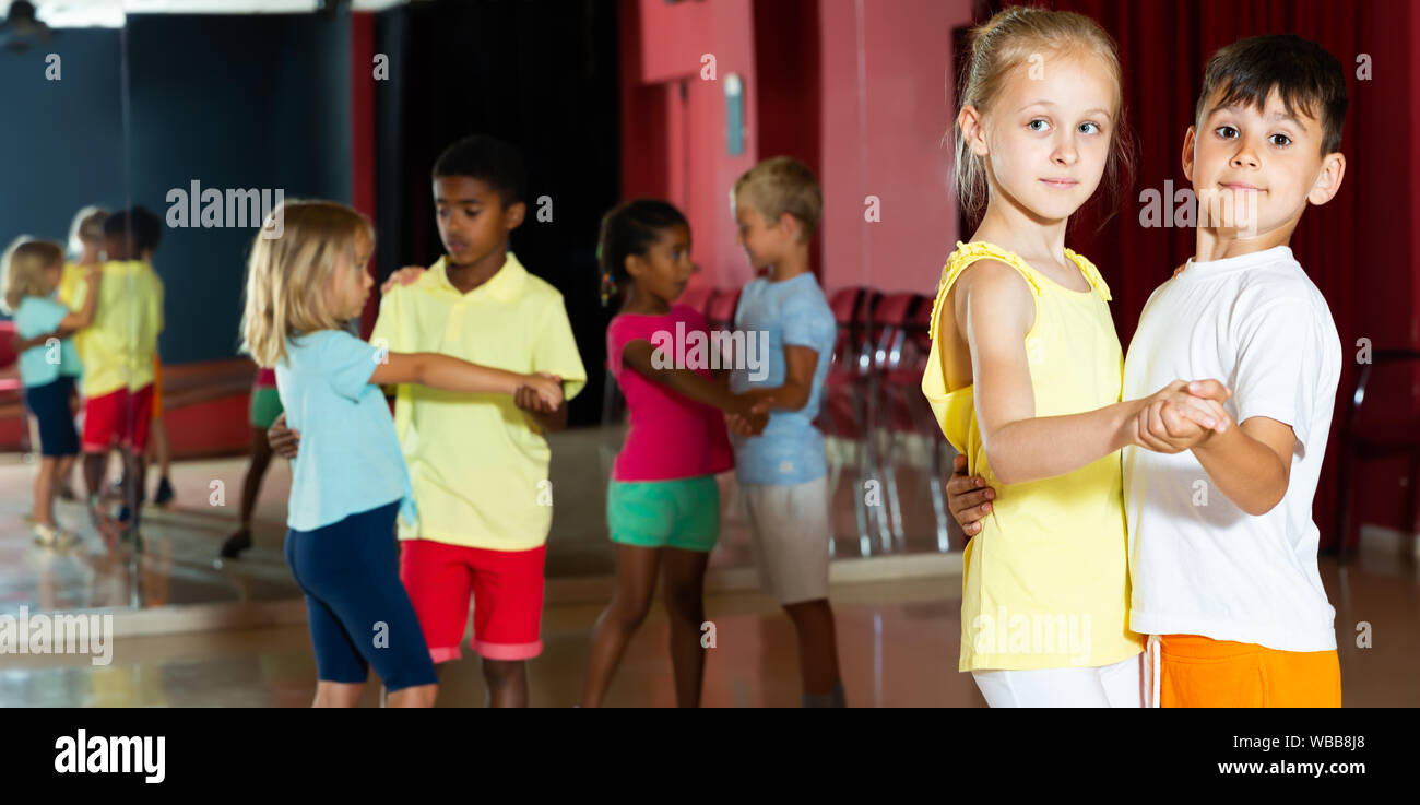 Group of glad children dancing salsa dance in modern studio Stock Photo ...