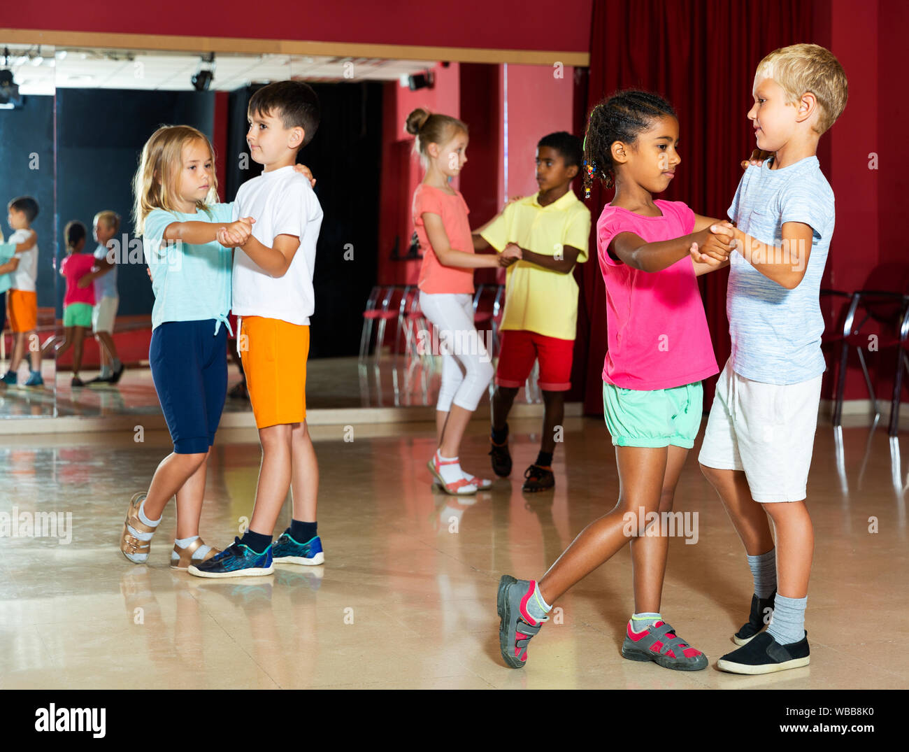Positive kids primary school trying dancing of partner dance in modern ...