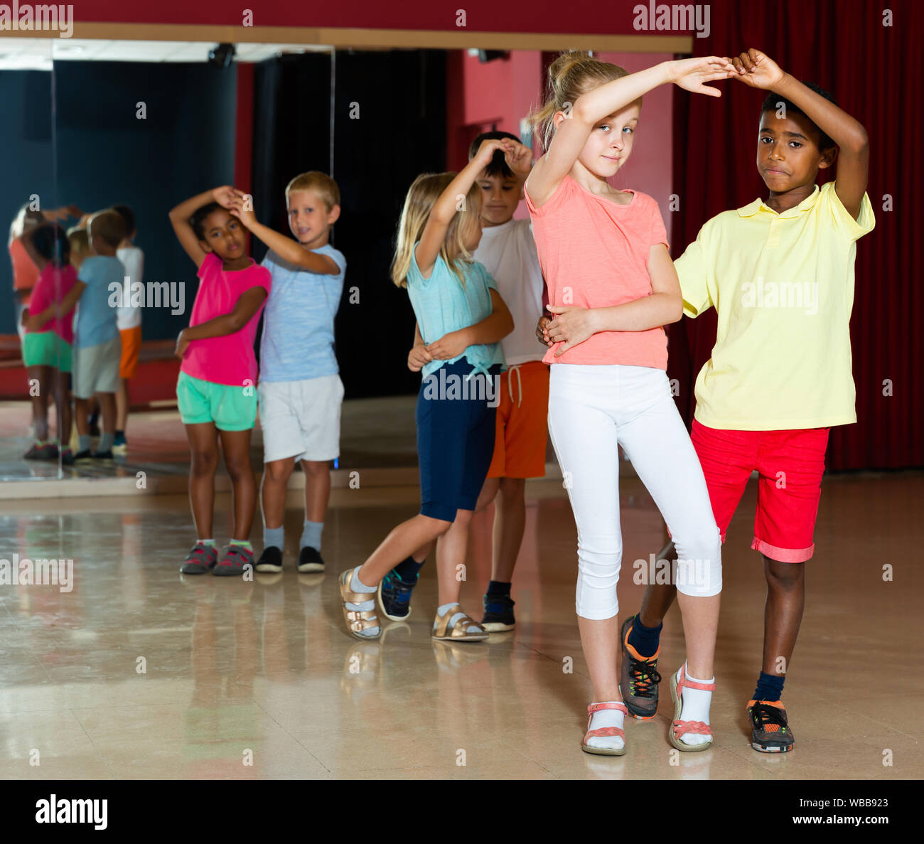 Group of cheery kids dancing salsa dance in modern studio Stock Photo ...