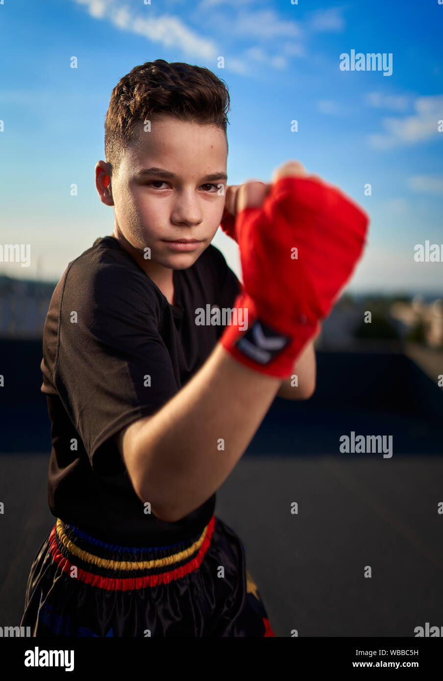 Young muay thai fighter or kickboxer training on the roof above the ...