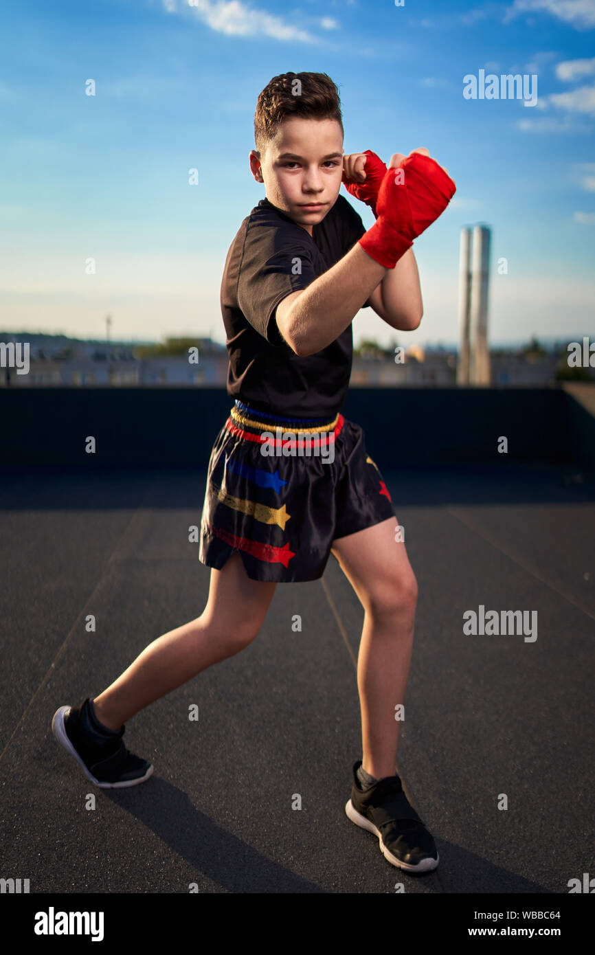 Young muay thai fighter or kickboxer training on the roof above the ...