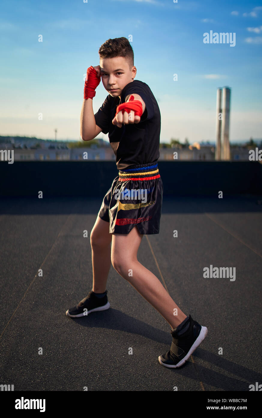 Young muay thai fighter or kickboxer training on the roof above the ...
