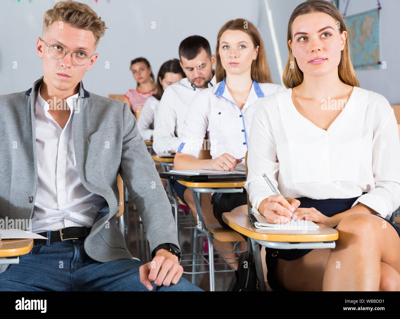 Small group of students attentively listening to lecture in classroom ...