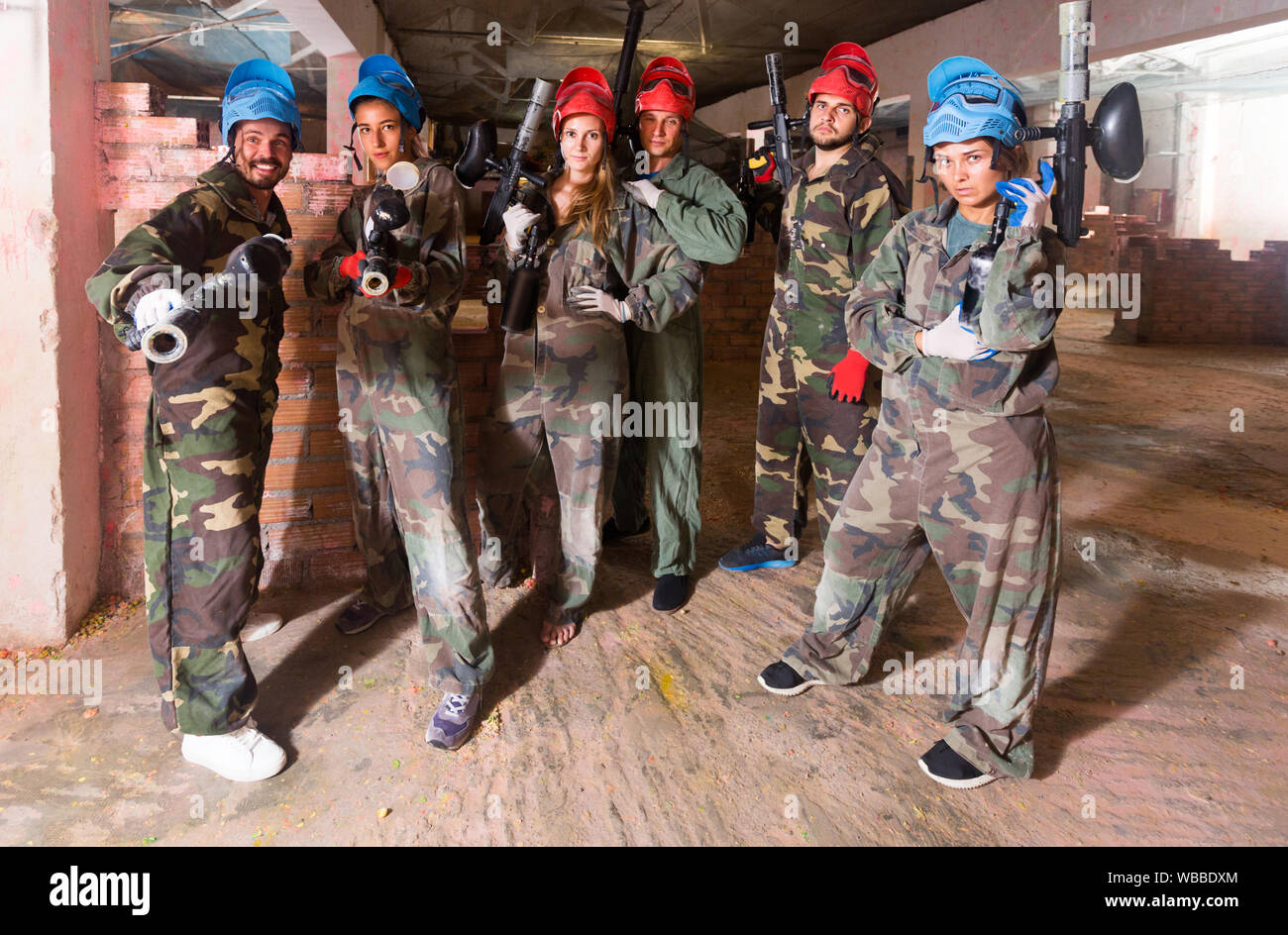 Portrait of red and blue teams who are ready for paintball playing ...