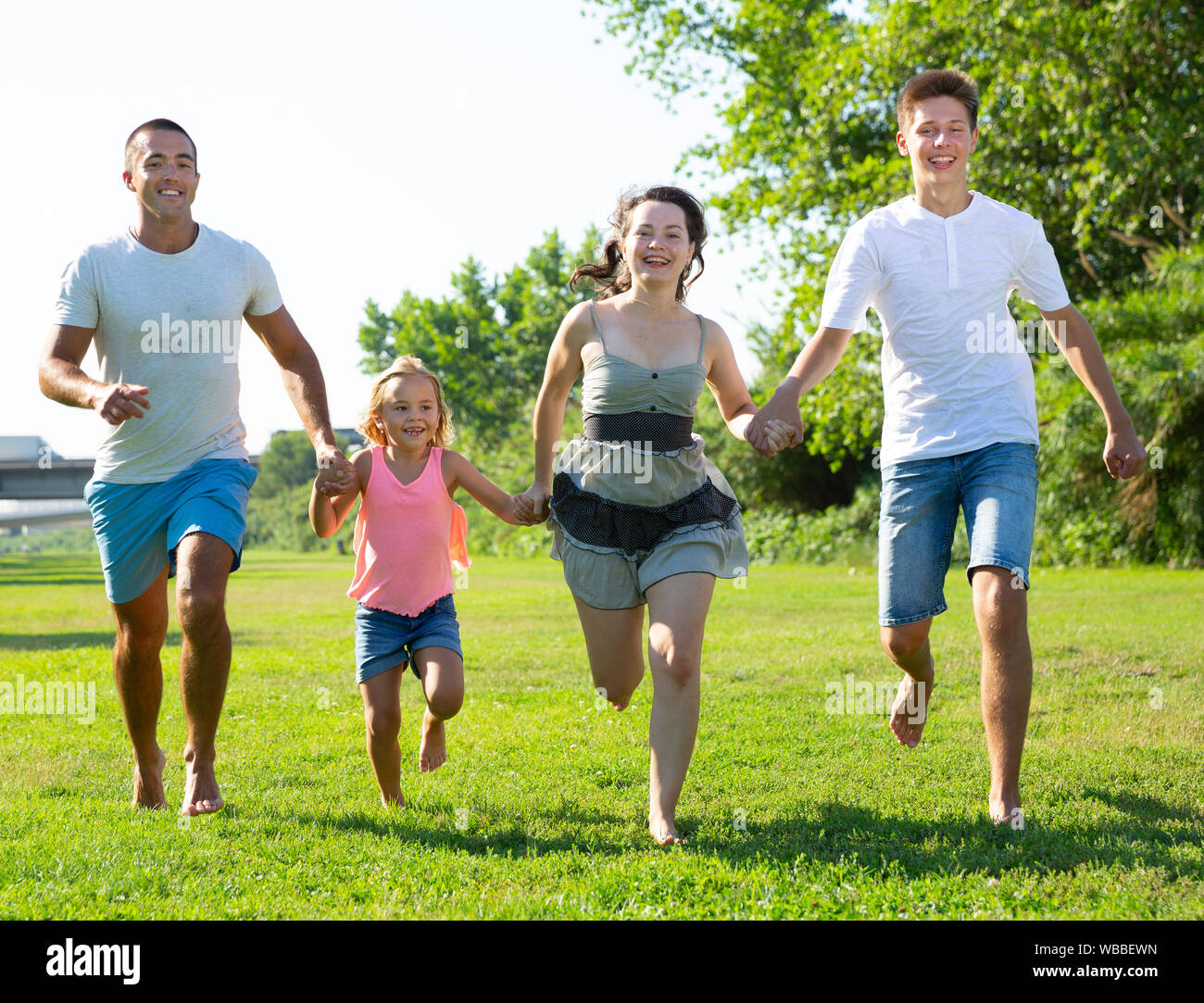 Cheerful family with two children having fun together, running in ...