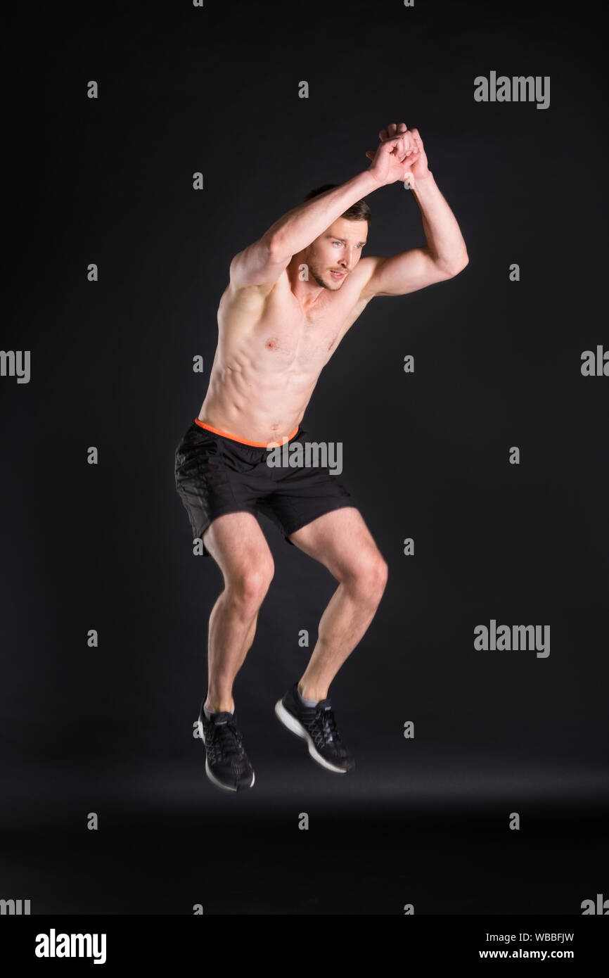 Muscular athlete man doing exercise on the black background Stock Photo ...