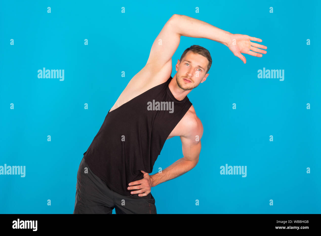 Muscular athlete man doing exercise on the blue background Stock Photo ...