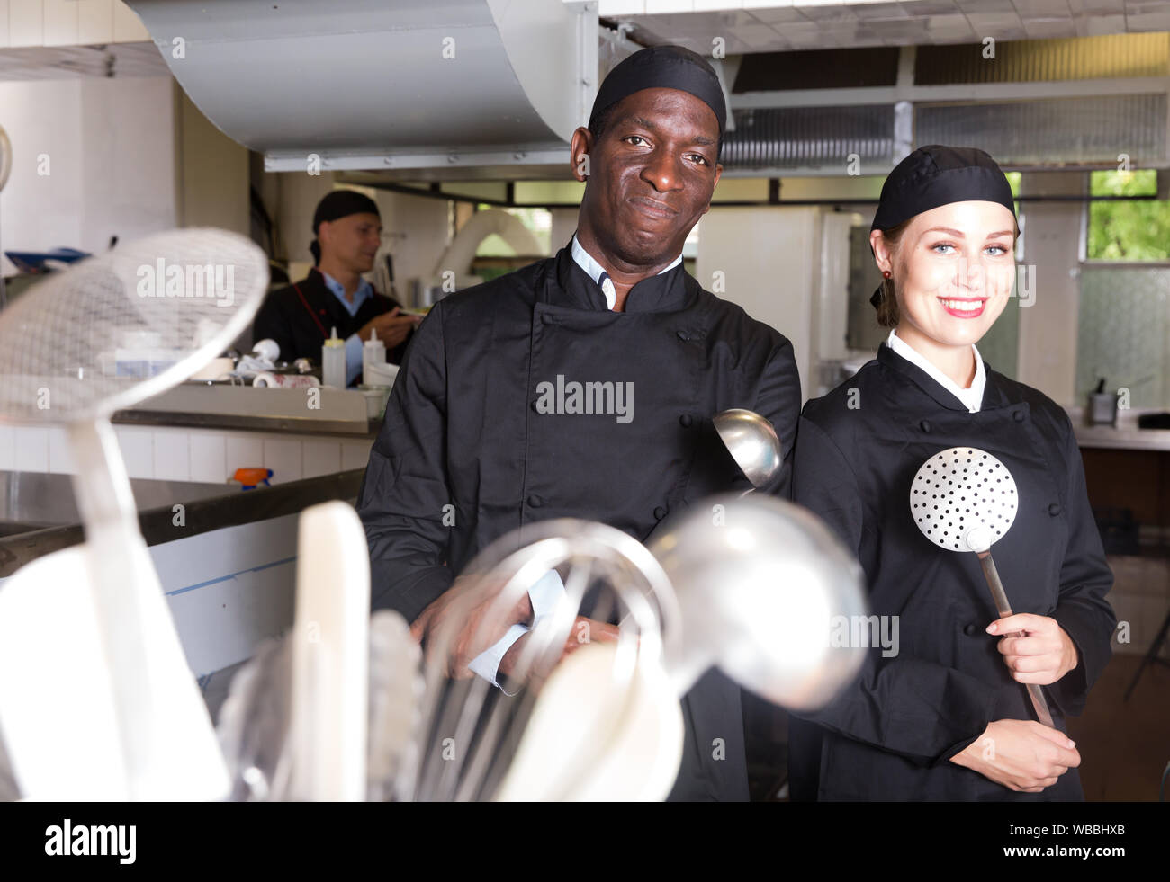 Portrait of two smiling confident chefs posing together in modern ...