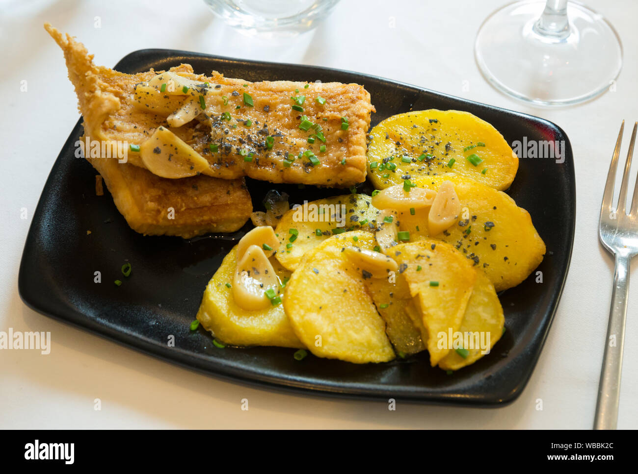 Delicious spicy breaded roasted ray wings served with potatoes. Typical ...