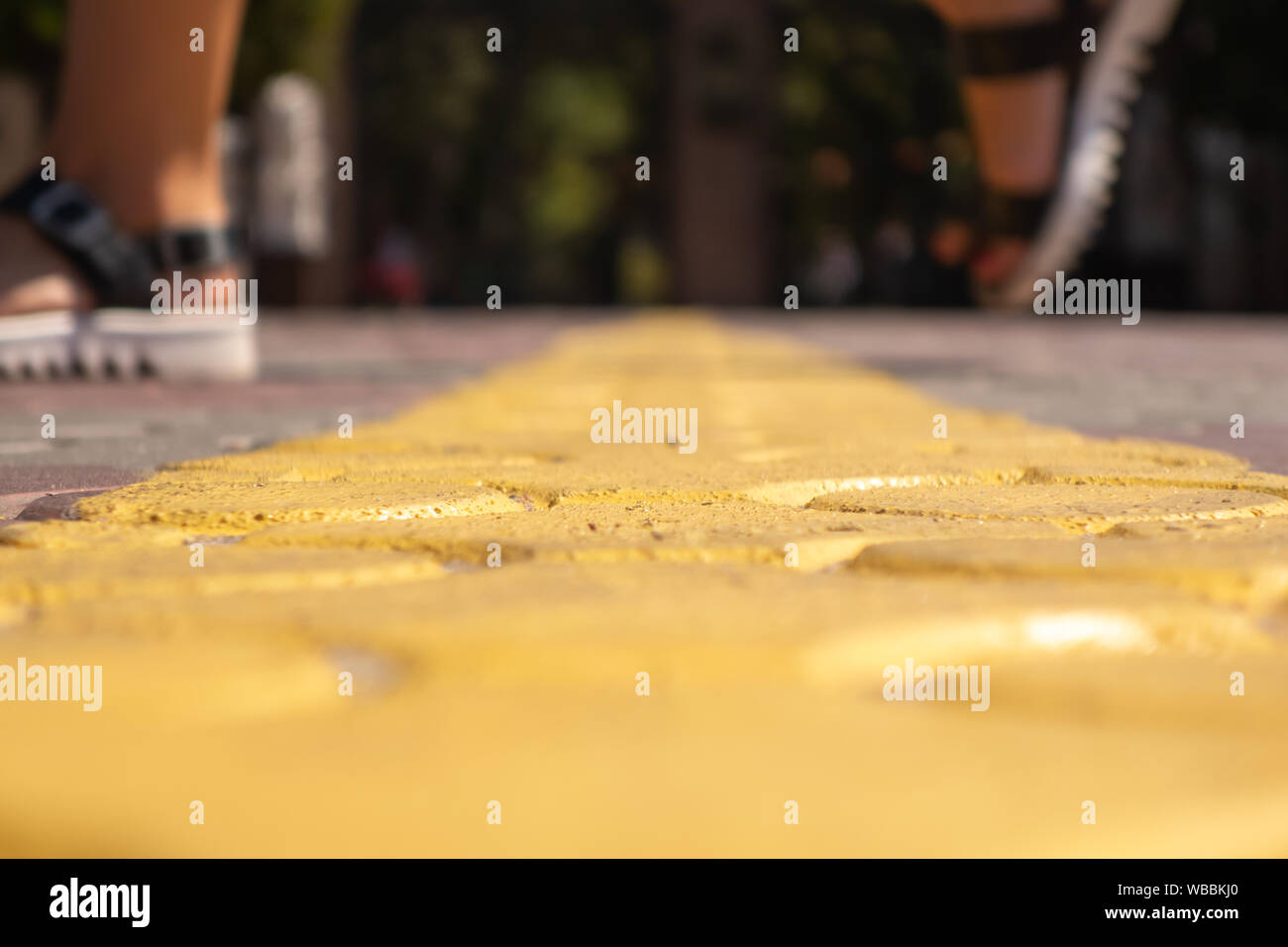 Yellow dividing strip on the paving stones, extending into the distance ...