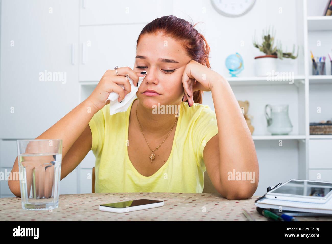 crying teenage girl looking at silent mobile phone indoors Stock Photo ...