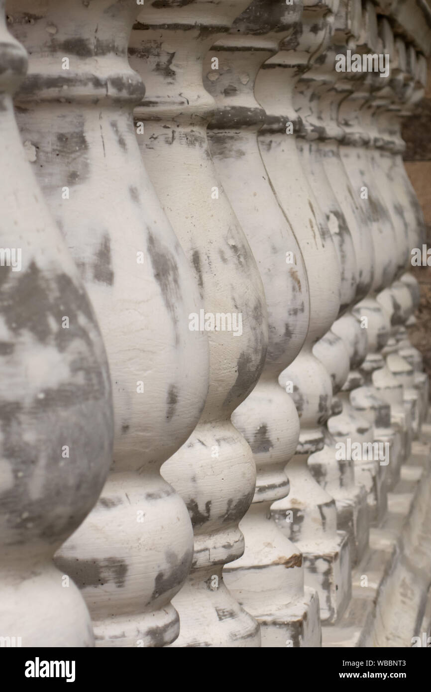 Antique balusters of gray color with cracked white paint. Linear ...