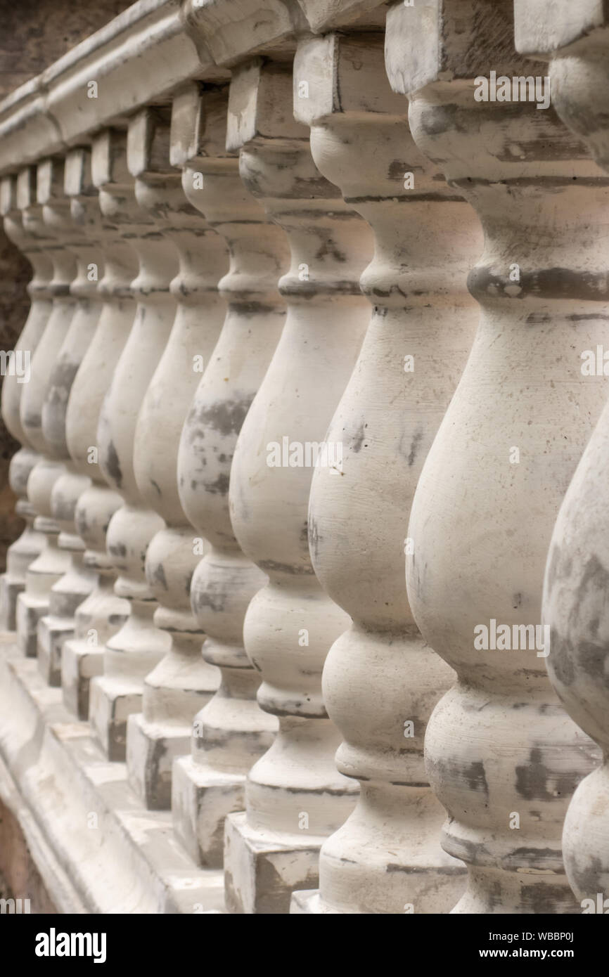 Antique balusters of gray color with cracked white paint. Linear ...