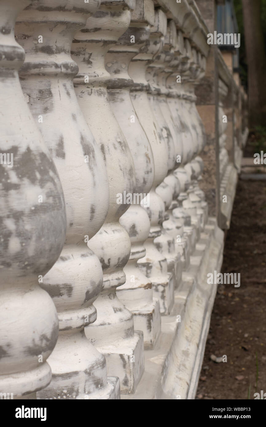Antique balusters of gray color with cracked white paint. Linear ...
