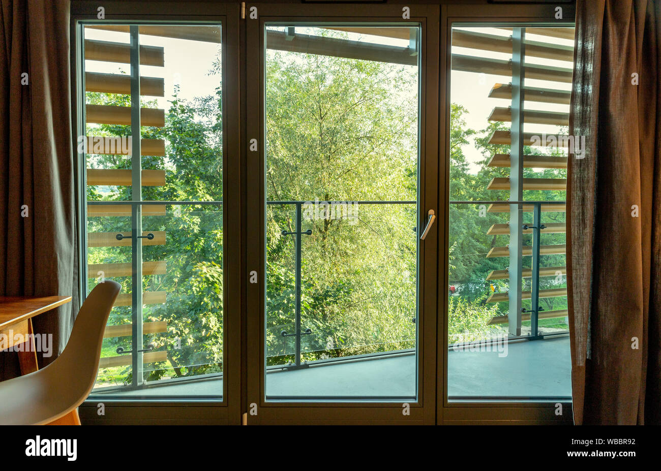 View on trees from balcony of a modern apartment Stock Photo - Alamy