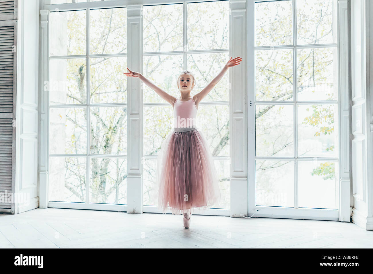 Young classical ballet dancer girl in dance class. Beautiful graceful ballerina practice ballet ...