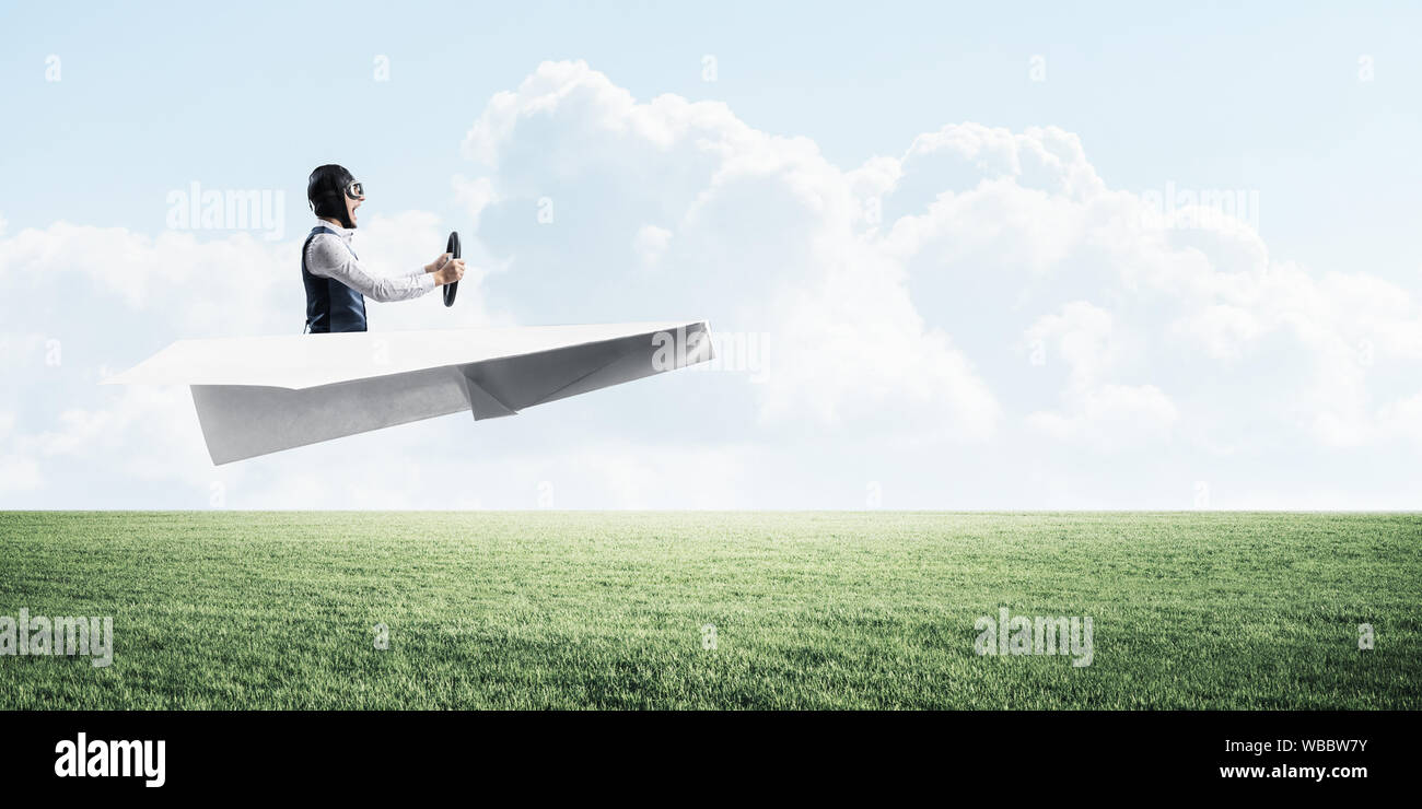 Happy aviator driving small paper plane on background of natural ...